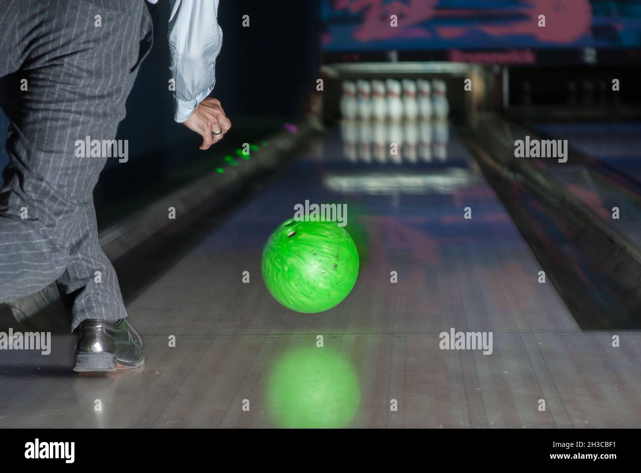 Person throwing a green bowling ball Stock Photo - Alamy