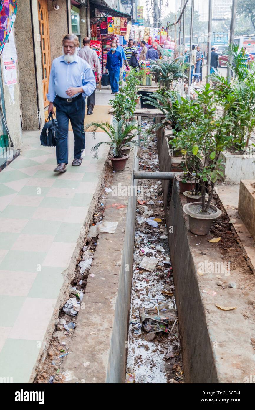 DHAKA, BANGLADESH - NOVEMBER 20, 2016: People walk along deep canal ...