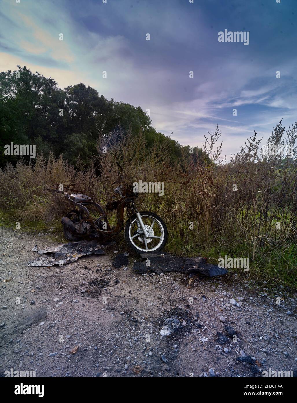 Wide landscape with burned out bike on recreational land Stock Photo ...