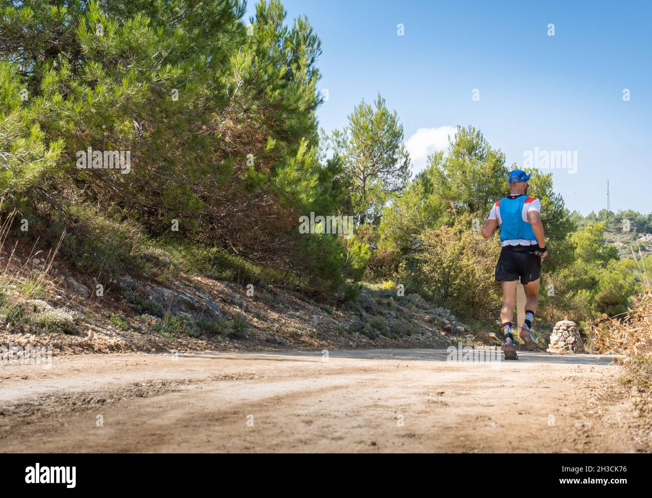 Back view of a young man running down a dirt track in nature Stock ...