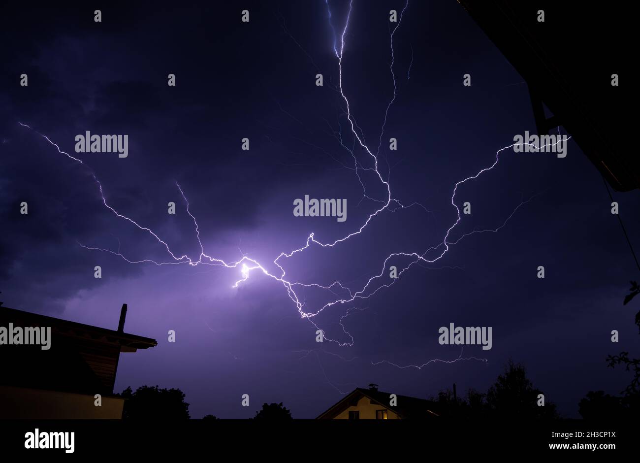 Closeup of lightning strikes in a dark night sky over a village Stock ...