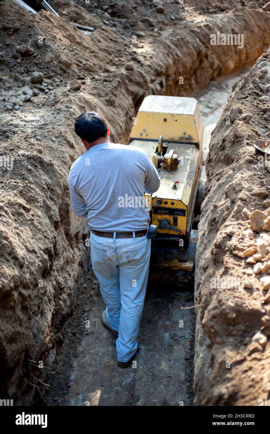 Construction worker operating a walk-behind a vibration compacting ...