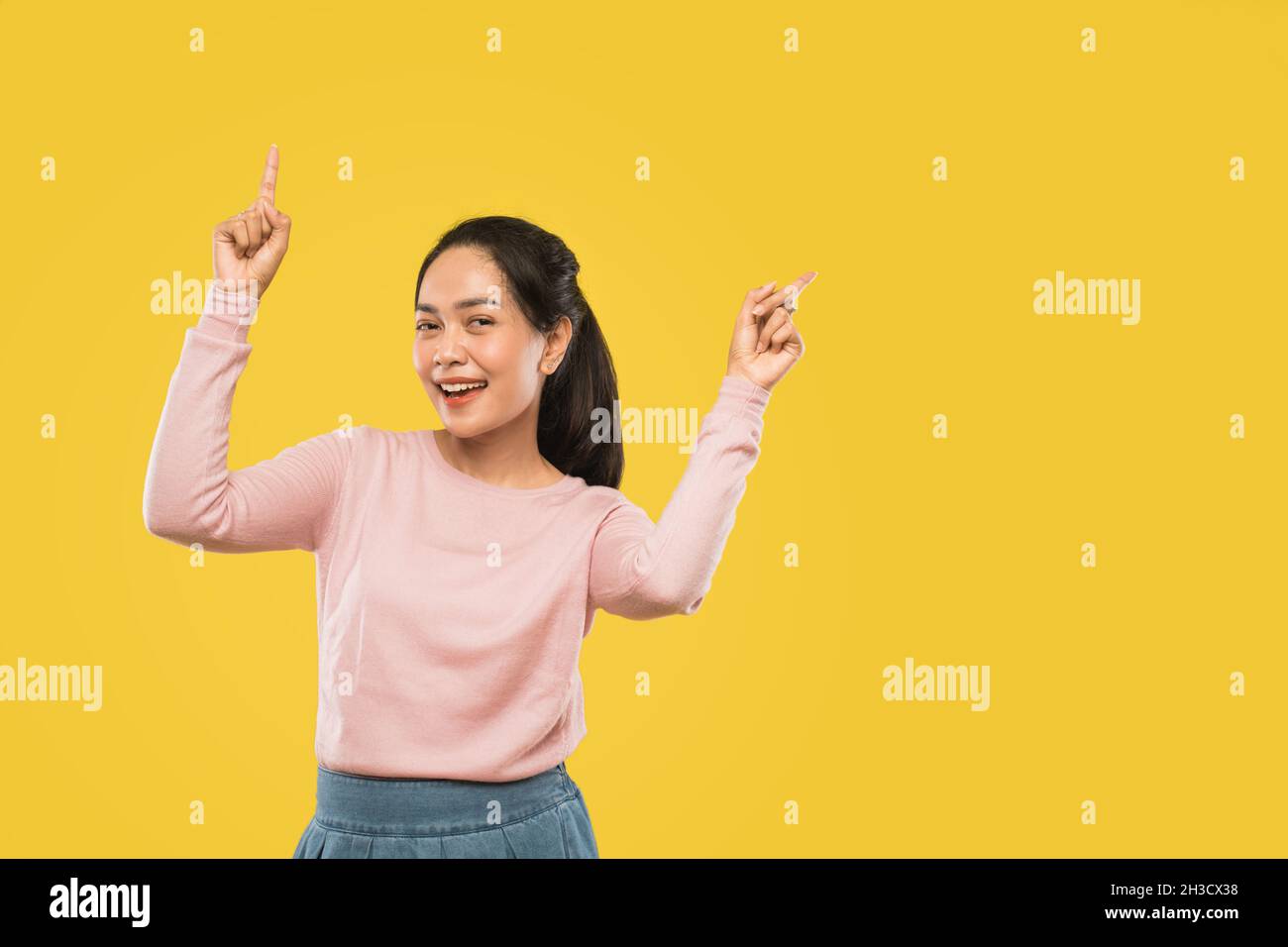 beautiful young asian woman with two hands pointing up Stock Photo - Alamy