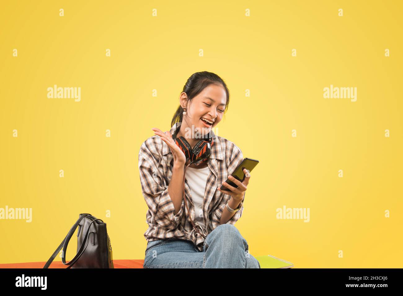 happy girl reading message while looking at phone screen while sitting ...