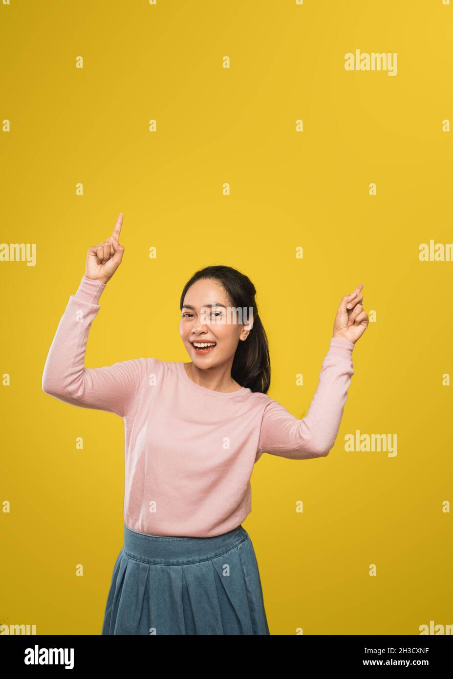 beautiful young woman smiling with two hands pointing up Stock Photo ...