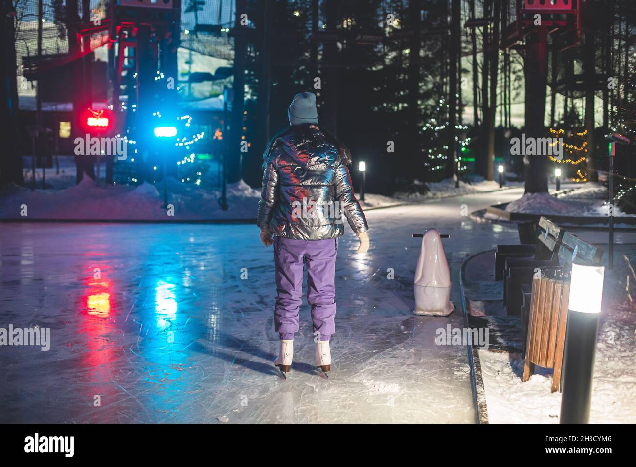 Girl ice skating on the ice rink arena with happy people around ...