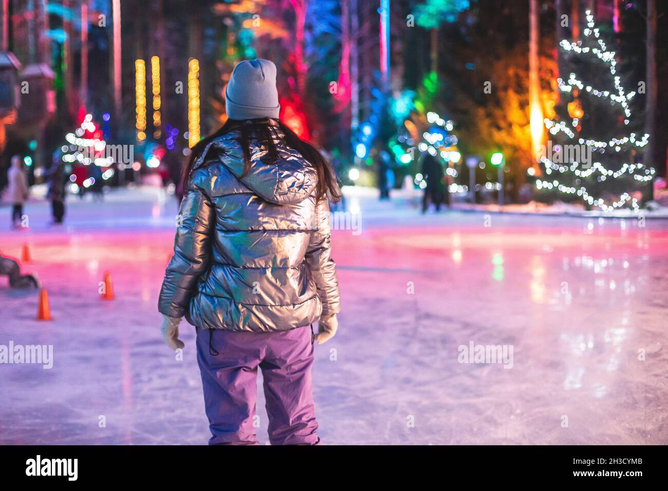 Girl ice skating on the ice rink arena with happy people around ...