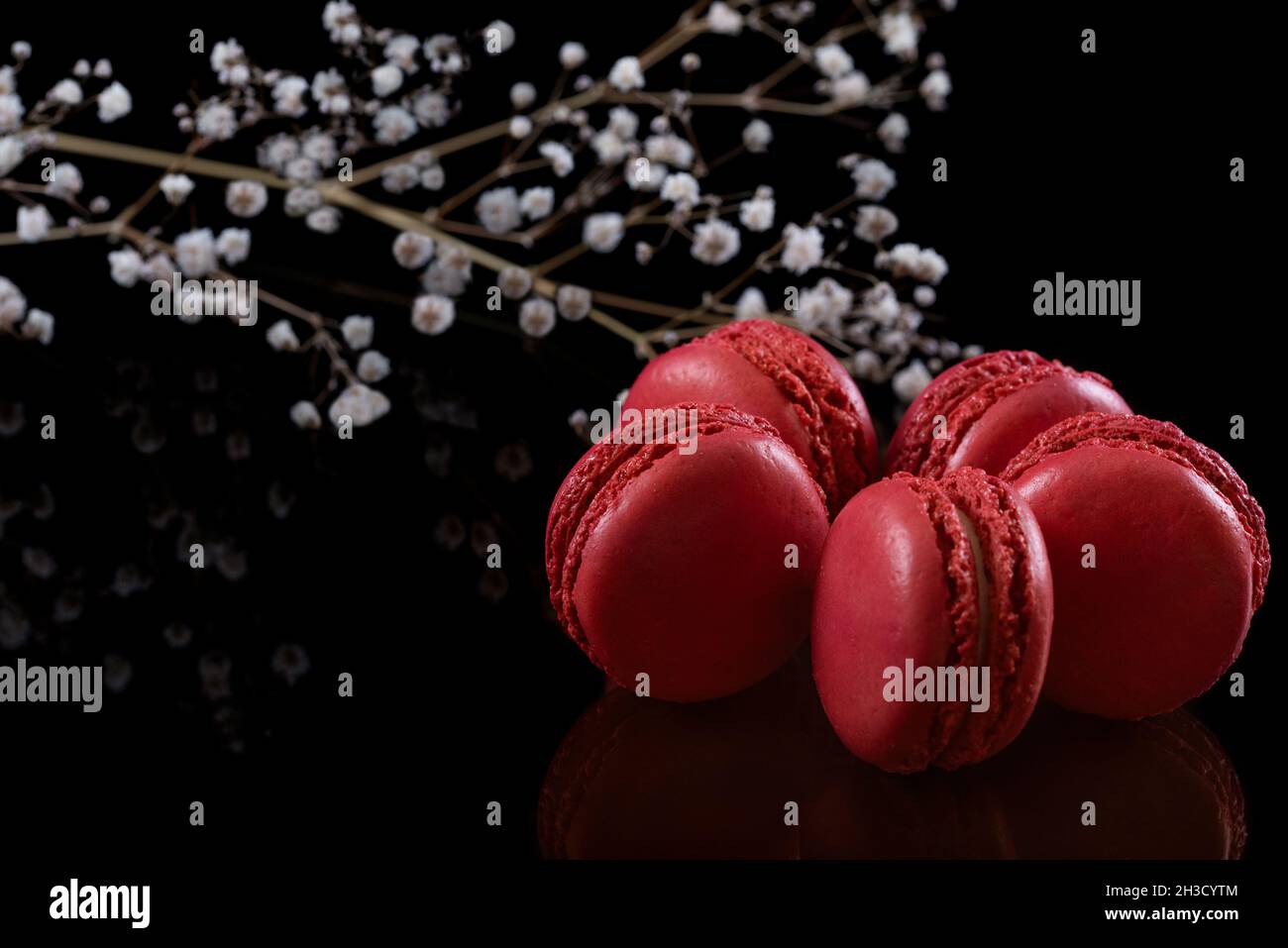 Red French Macarons with Flowers on Black Background. High quality ...