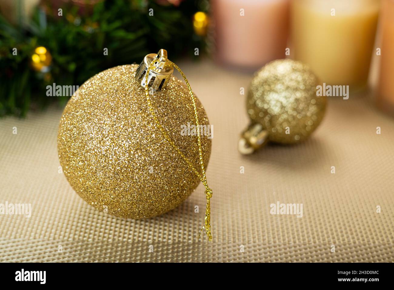 Close up of golden Christmas baubles on metallic yellow background ...
