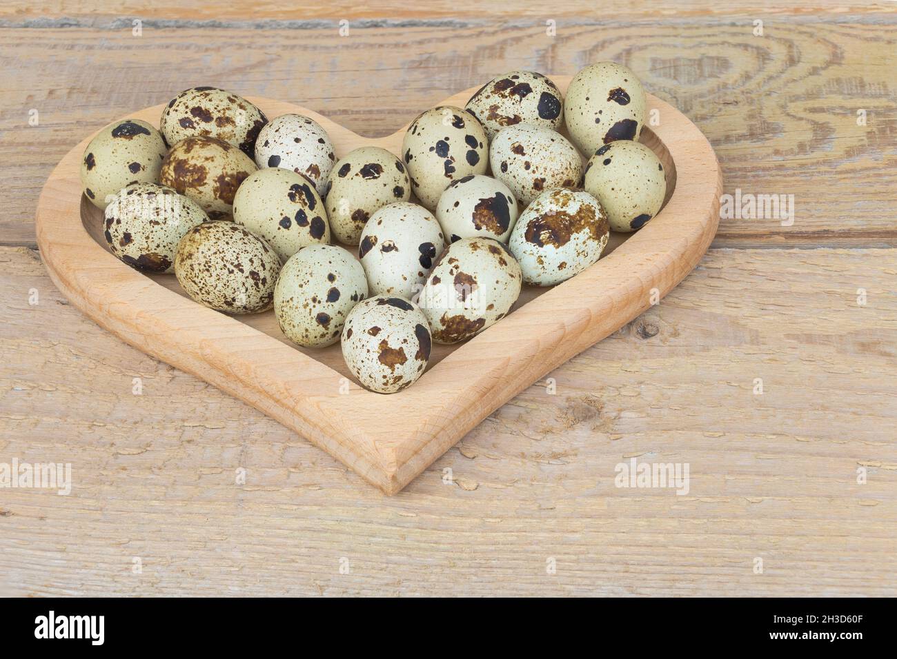Quail eggs in a heart-shaped wooden plate Stock Photo - Alamy