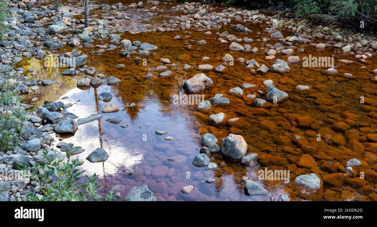 Water running down the river around rocks Stock Photo - Alamy