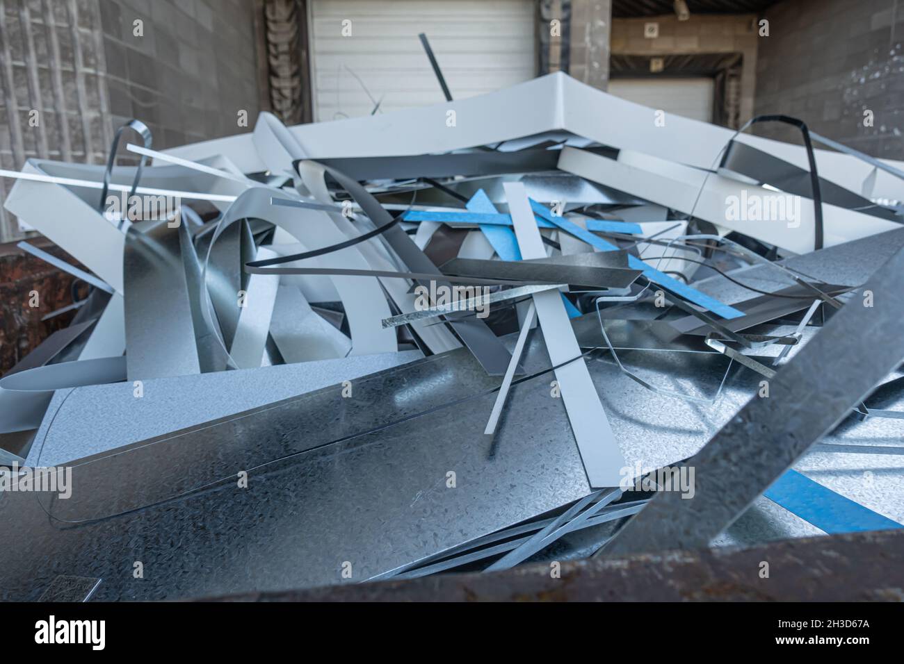 Garbage bin full of waste metal behind metal roofing factory Stock ...