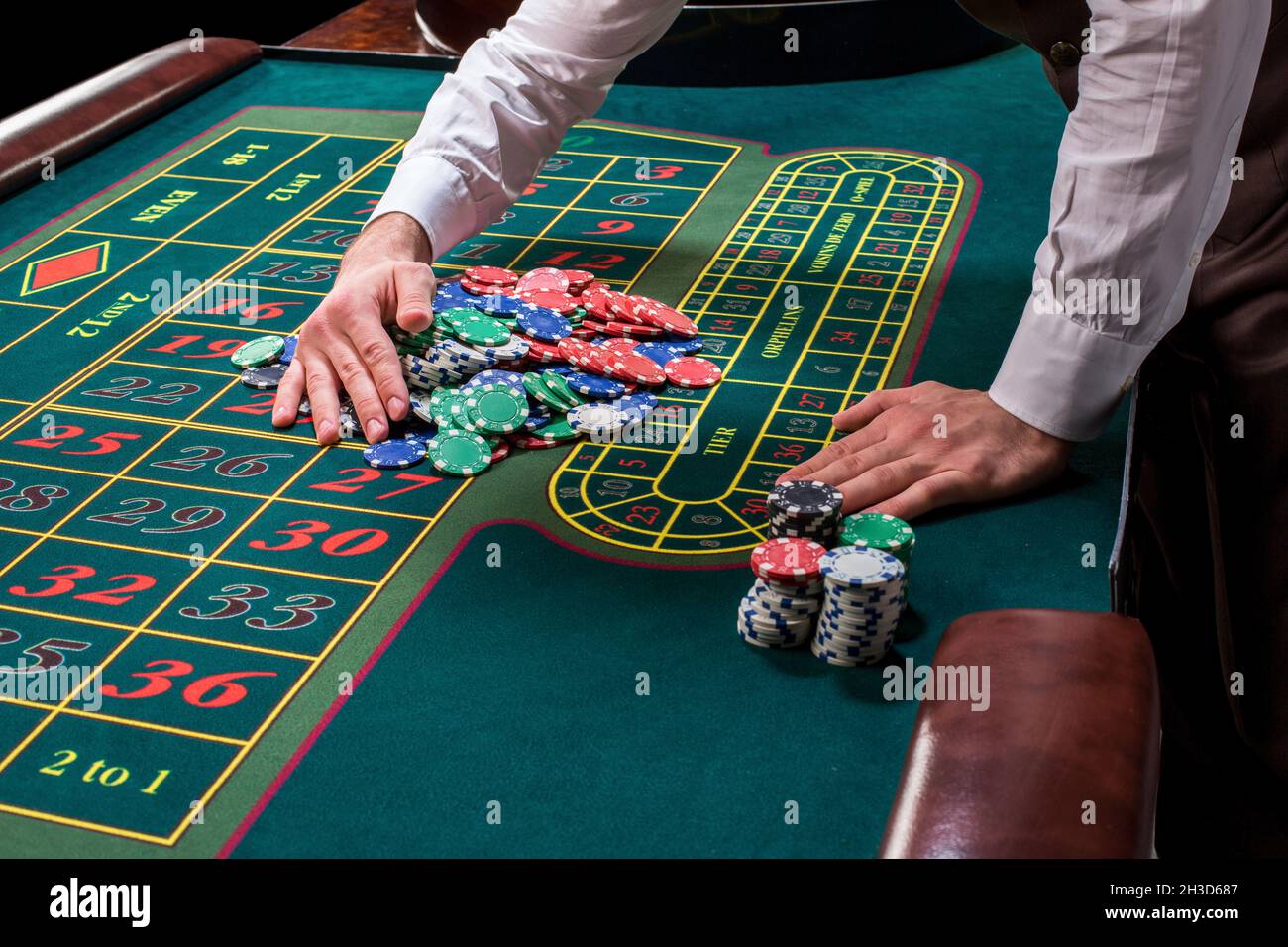 Croupier behind gambling table in a casino Stock Photo - Alamy