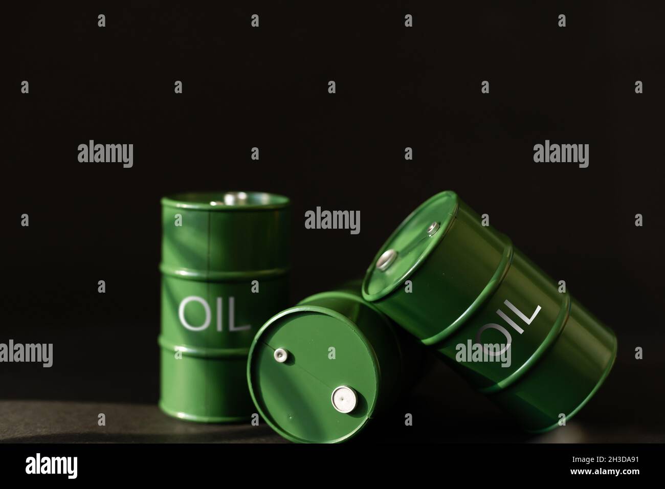 green oil tin barrels on black background Stock Photo - Alamy