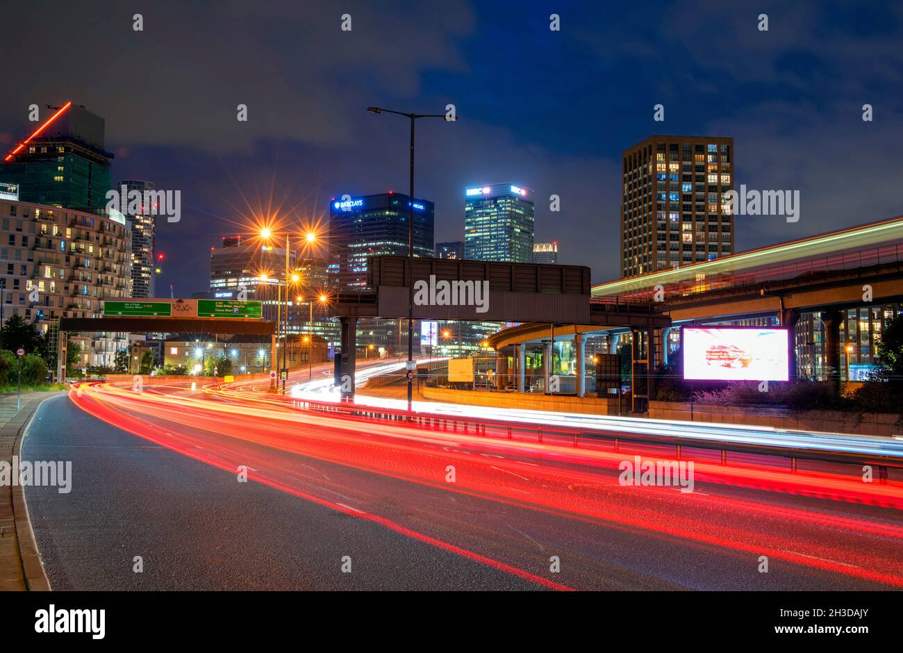 Traffic light trails on Aspen Way looking towards Canary Wharf, London ...