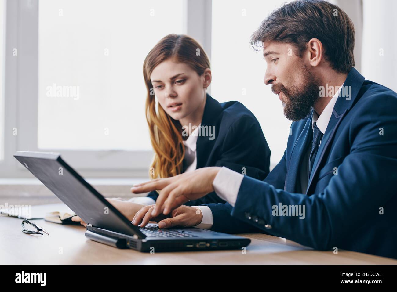 managers in the office in front of a laptop career work technologies Stock Photo - Alamy
