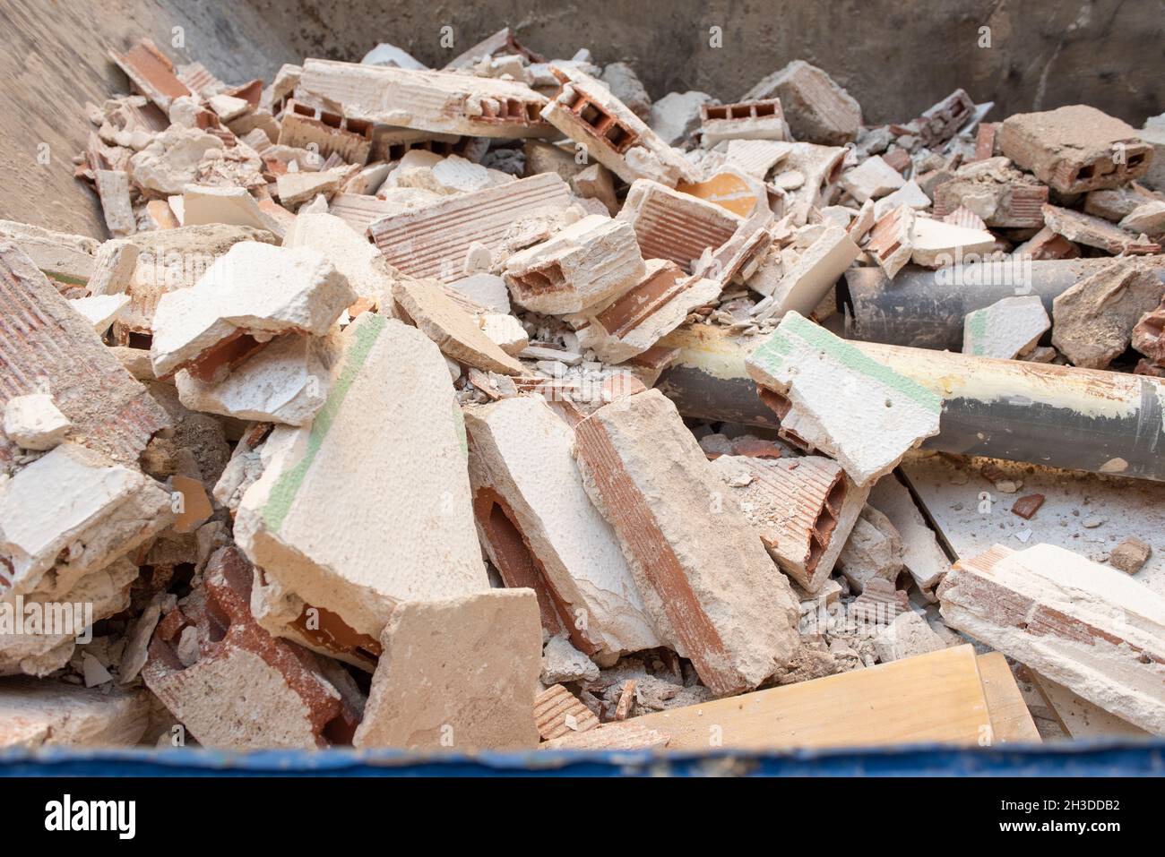 Construction waste, pvc pipes, plastered plaster bricks inside a metal ...