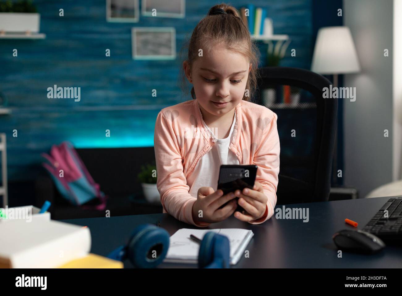 Schoolkid holding modern smartphone reading literature story using ...