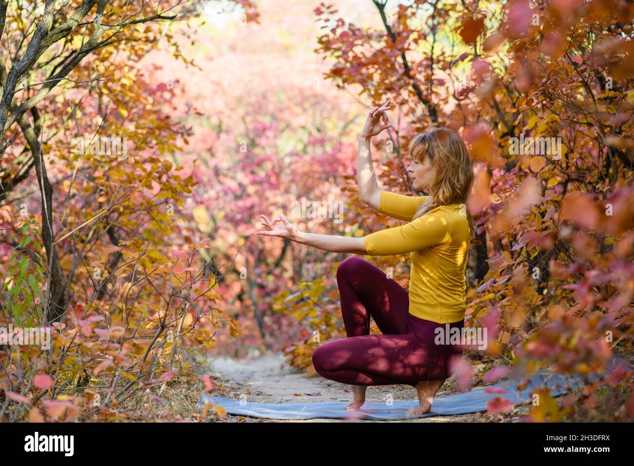 Woman practice yoga balance and meditation in autumn fall colorful ...