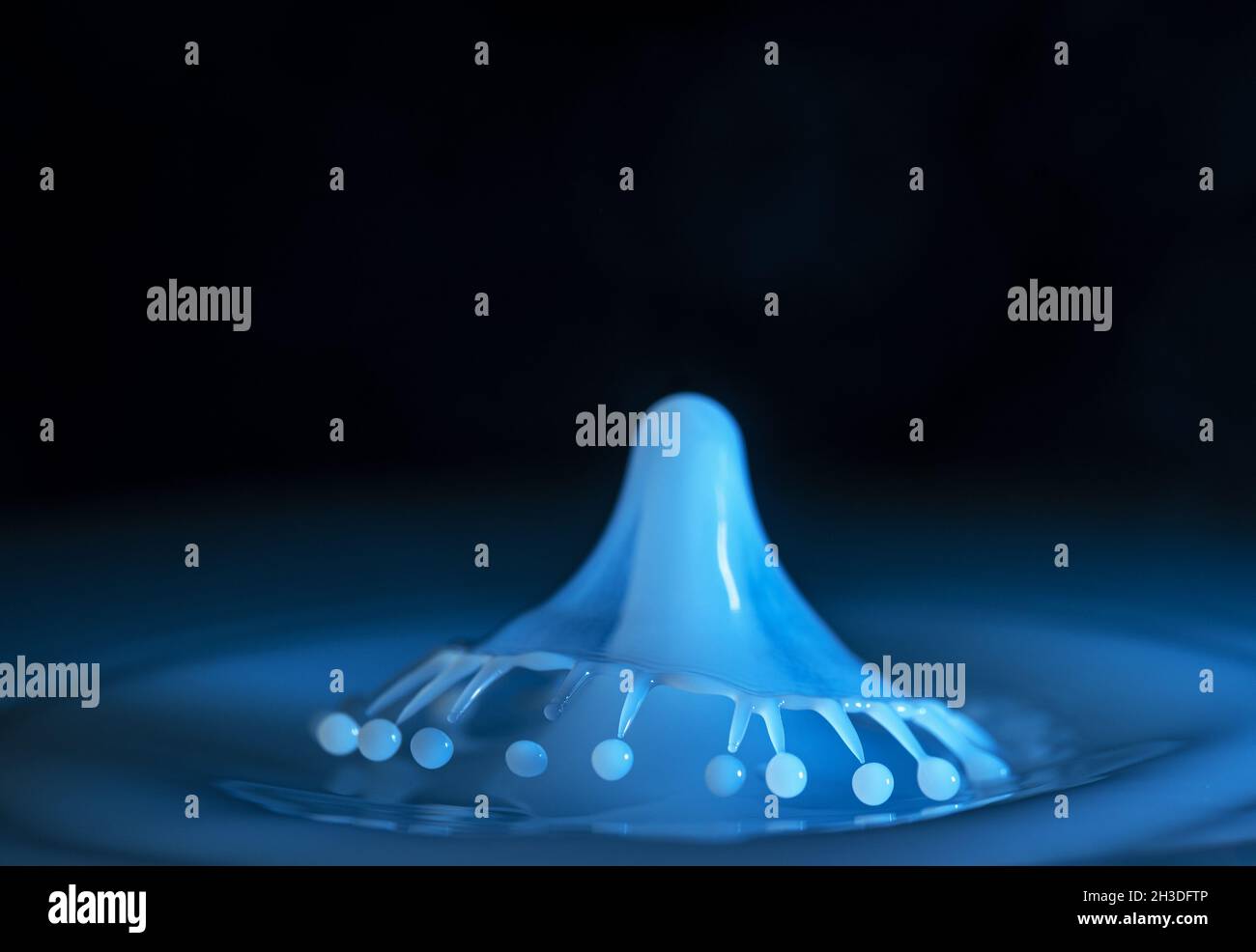 3d rendering of a drop falling on milk against a dark background Stock ...