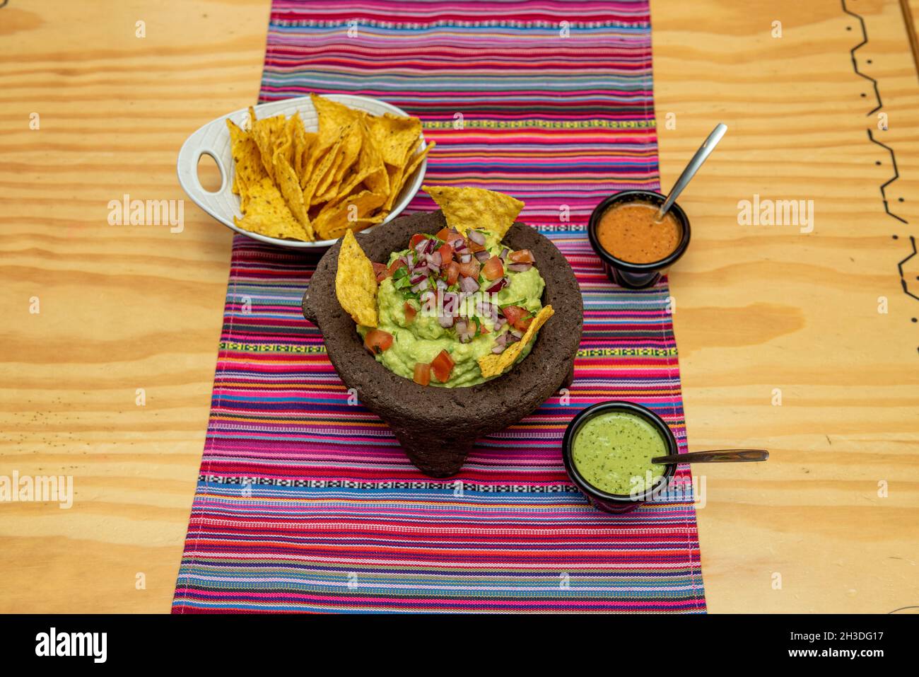 Mexican volcanic stone molcajete filled with guacamole with corn chips ...