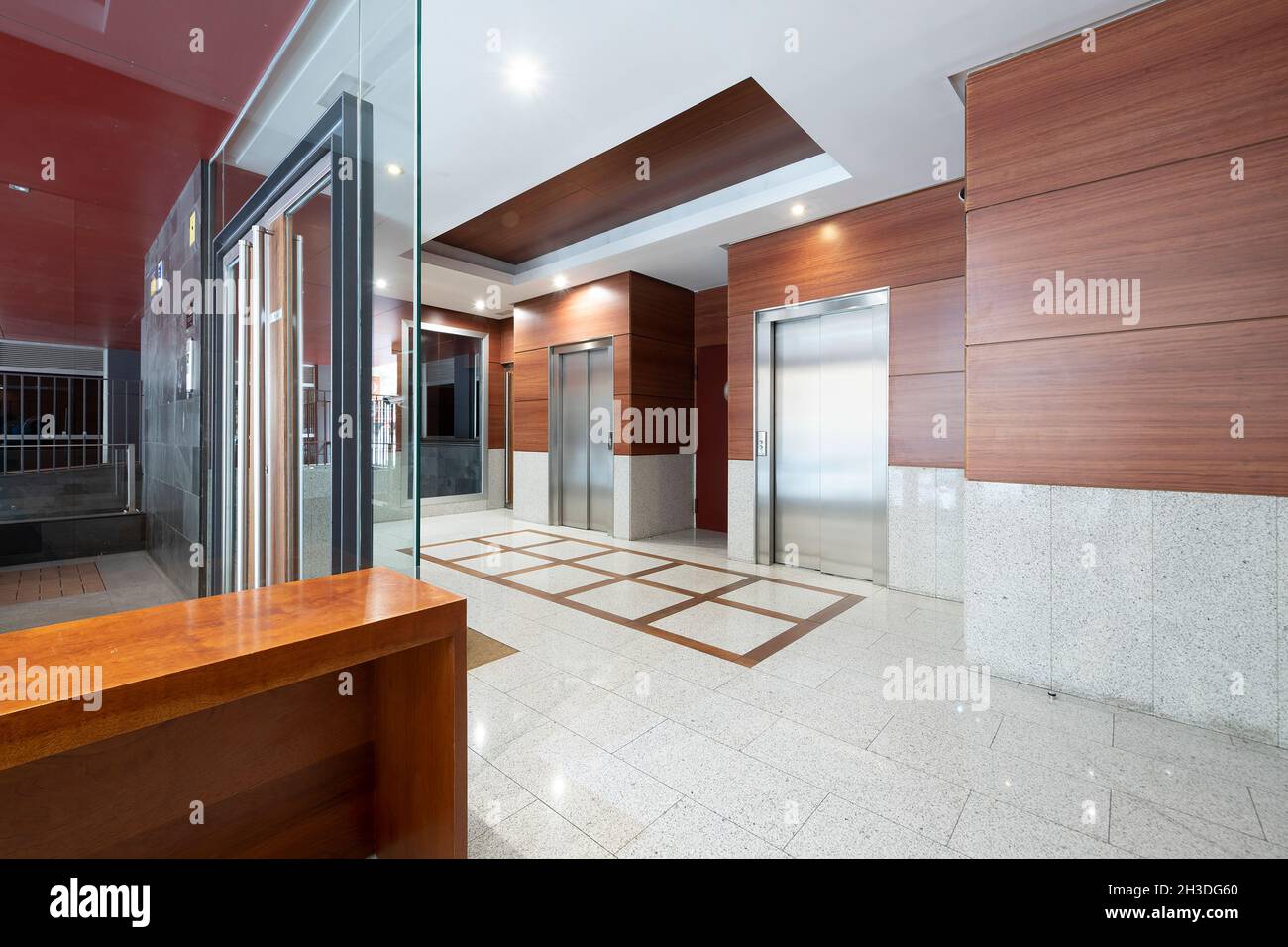 Lobby of an office building with elevators and granite and cherry wood ...