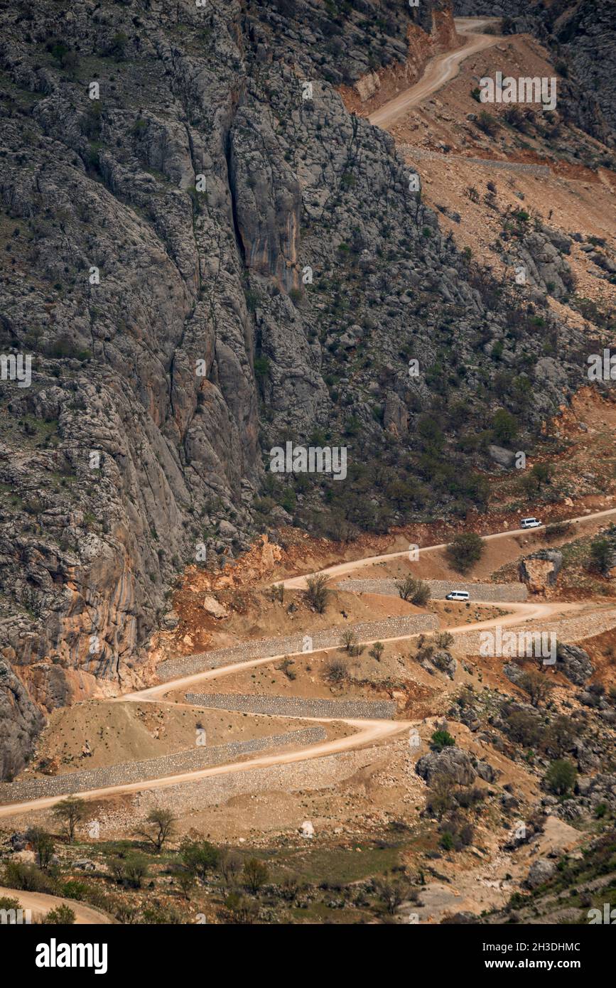 Very steep dirt track with several vans driving on it to cross a gorge ...