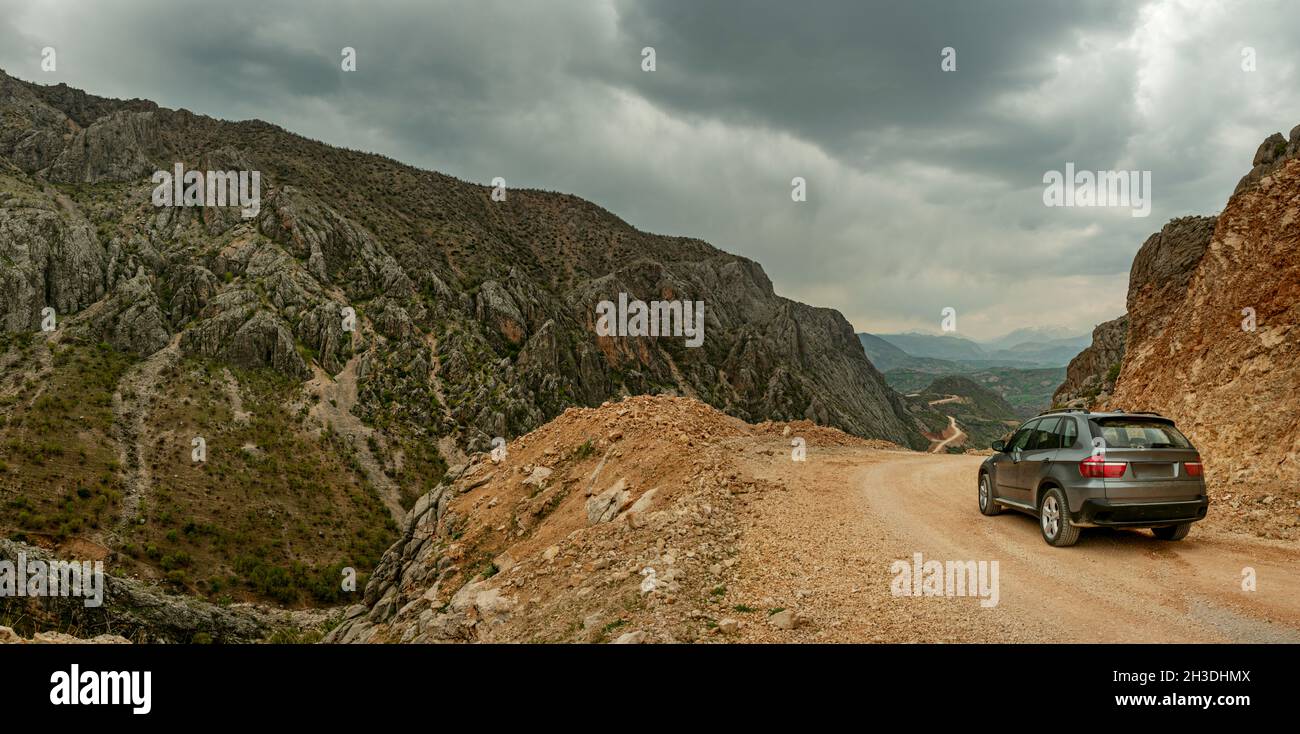 Dirt track crossing a mountain range with an off-road vehicle Stock ...