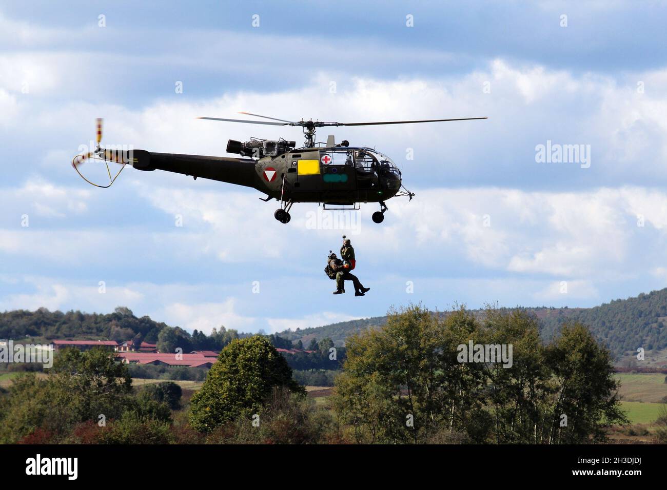 the red cross military helicopter carryng two people Stock Photo - Alamy