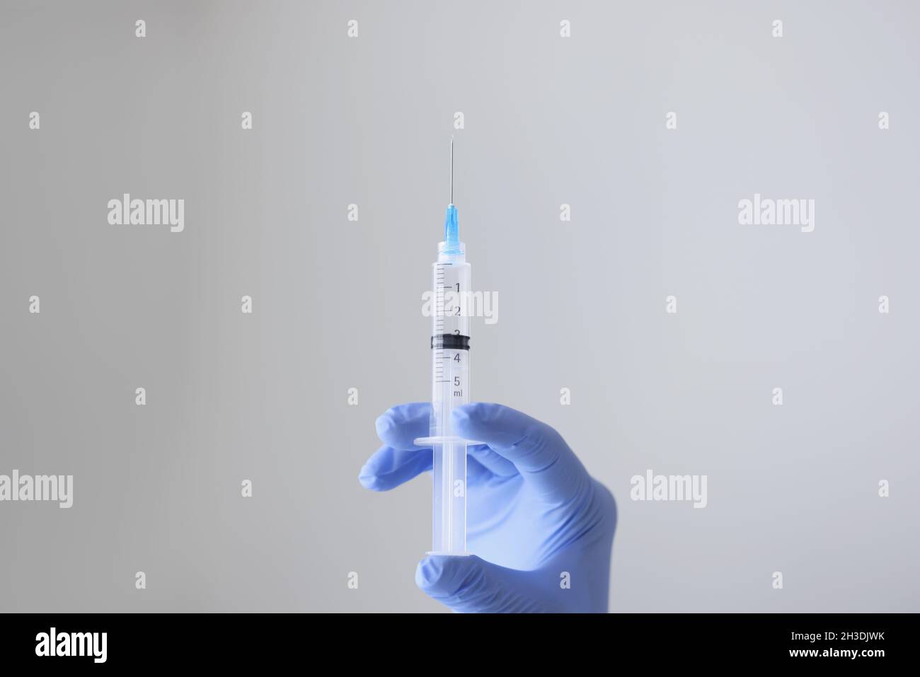 Close-up of person hand holding syringe with transparent substance ...
