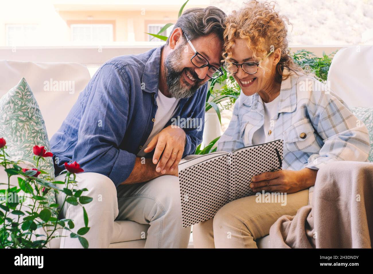 Happy And Cheerful Man And Woman Reading Together A Notebook Outside At