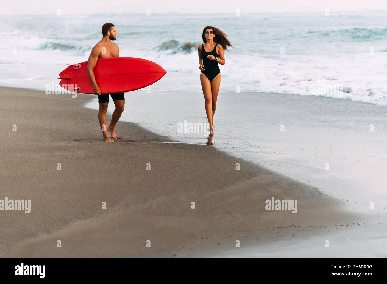 Couple In Love On The Beach With A Surfboard At Sunset Beautiful
