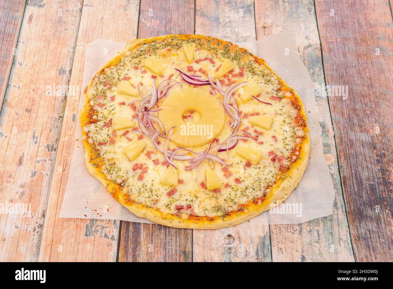 Tropical pizza with a slice of pineapple and slices around it with red ...