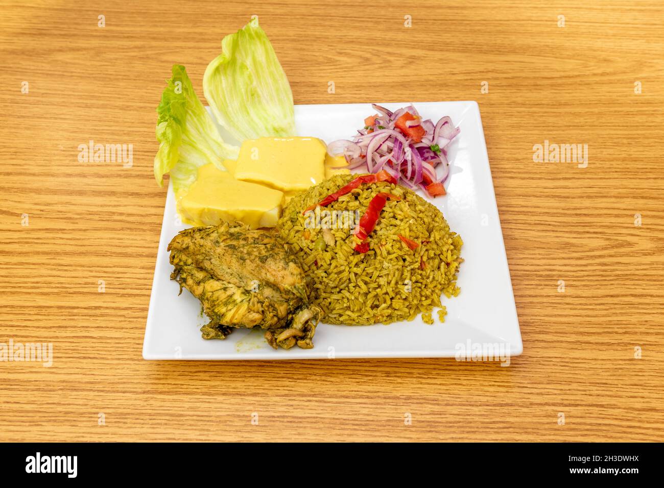 Portion of chicken with rice in Peruvian sauce with potatoes a la ...