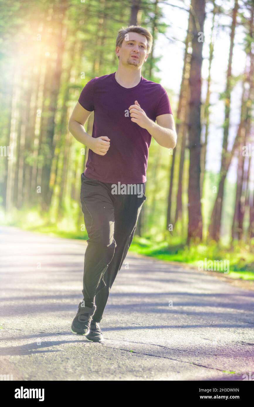 Running man jogging in city park at beautiful summer day. Sport fitness ...