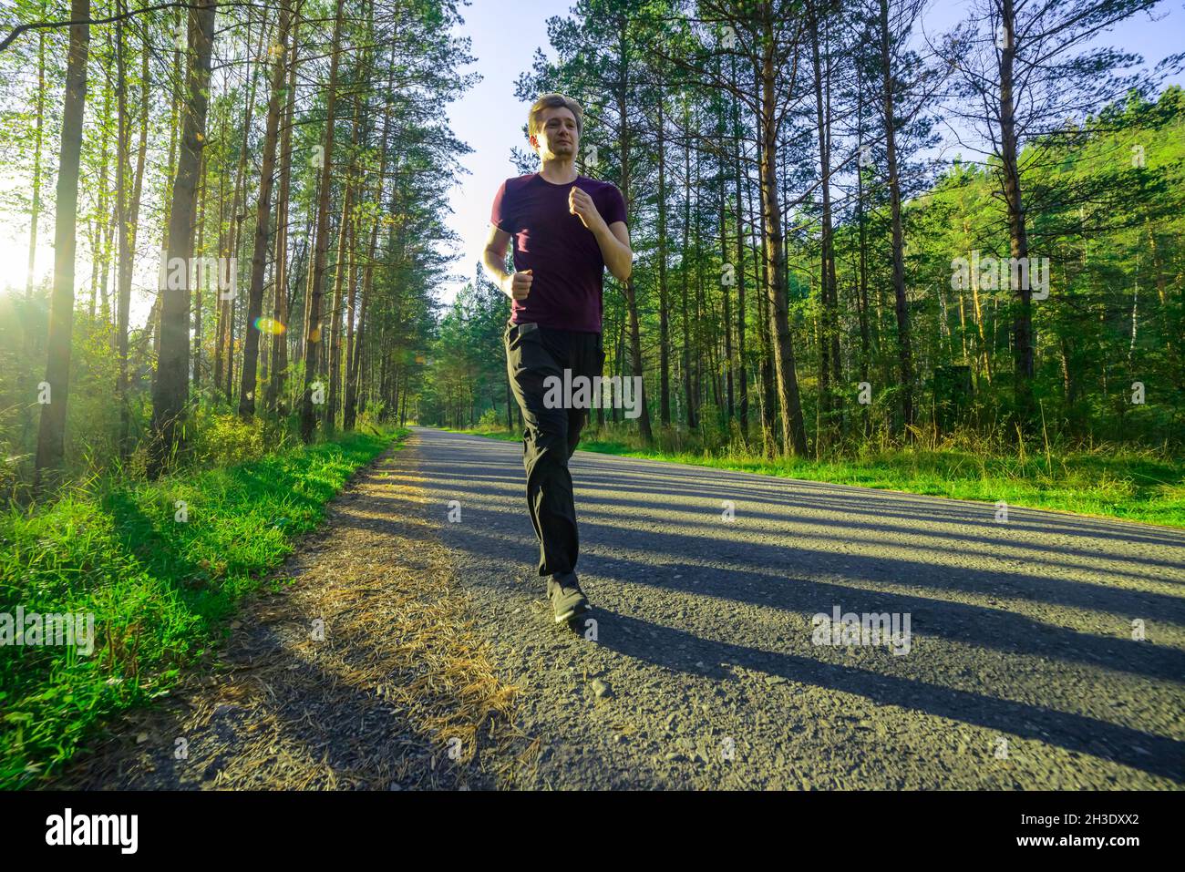 Running man jogging in city park at beautiful summer day. Sport fitness ...