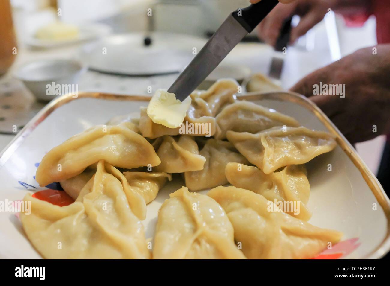 Ready manti on a plate with butter. Steamed dough with meat. Smear with ...
