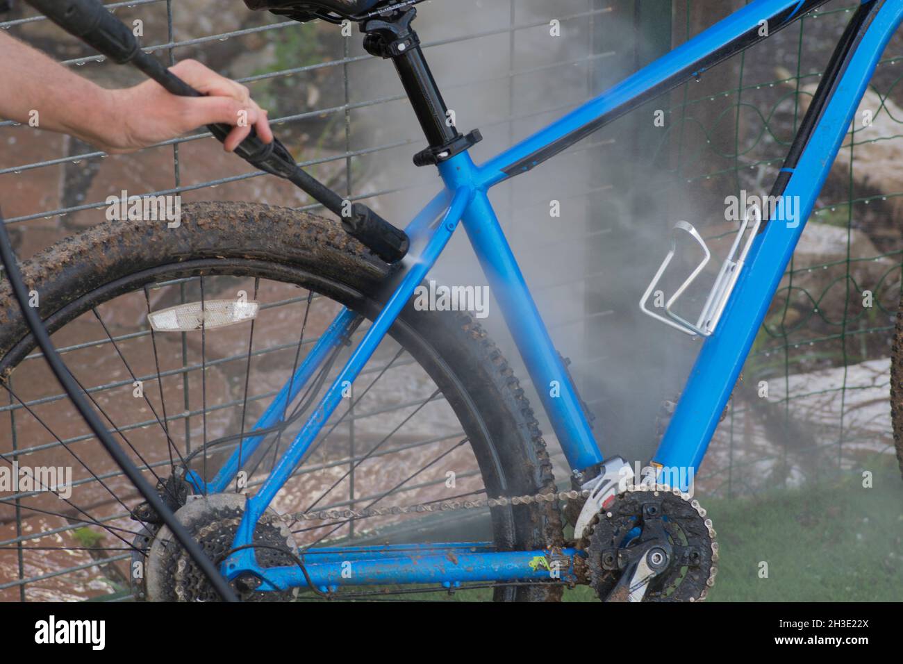 Man cleaning blue bicycle using high pressure washer Stock Photo - Alamy