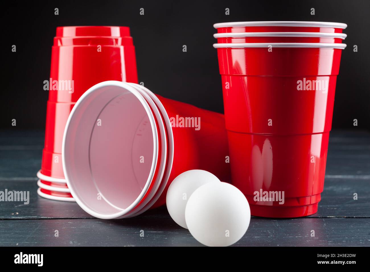 Wooden table with red cups and ball for beer pong Stock Photo - Alamy