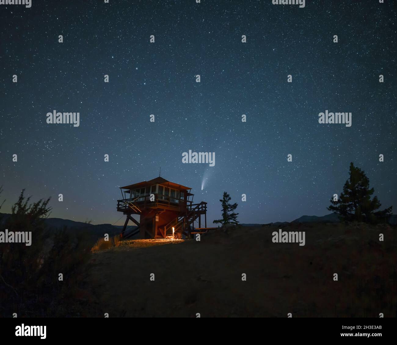 Scenic view of a comet shining on the starry sky over the landscape of ...