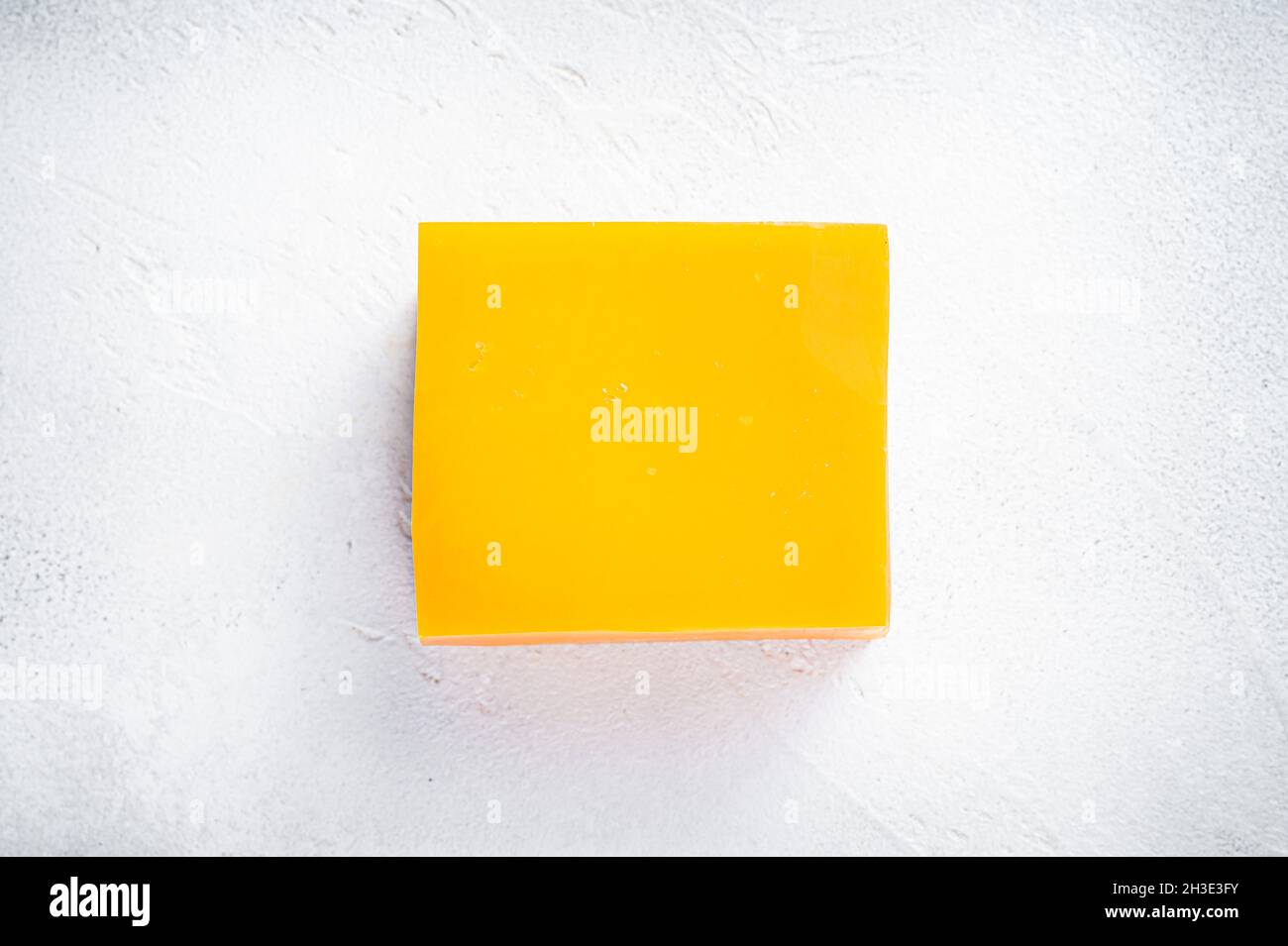 Cheddar Cheese block on a kitchen table. White background. Top view ...