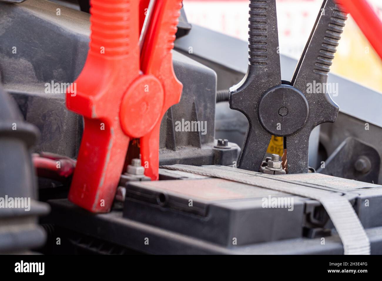 Starter clamps hooked to the terminals of a dusty old car battery Stock ...