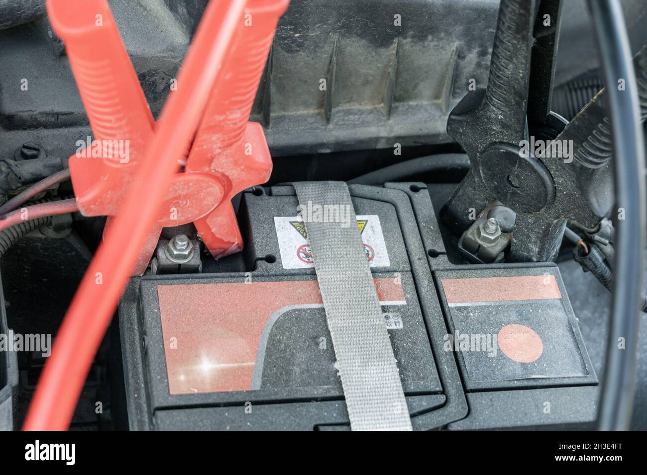 Starter clamps hooked to the terminals of a dusty old car battery Stock ...