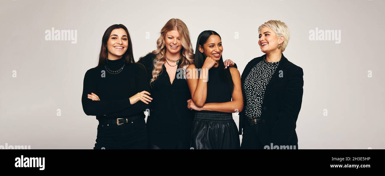 Happy group of women smiling in a studio. Four happy women looking ...
