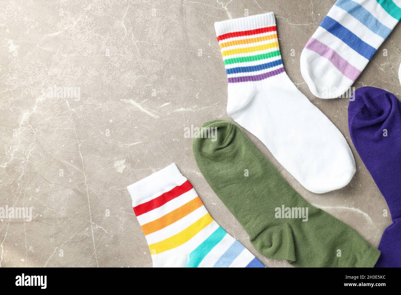Different color socks on gray textured background Stock Photo - Alamy