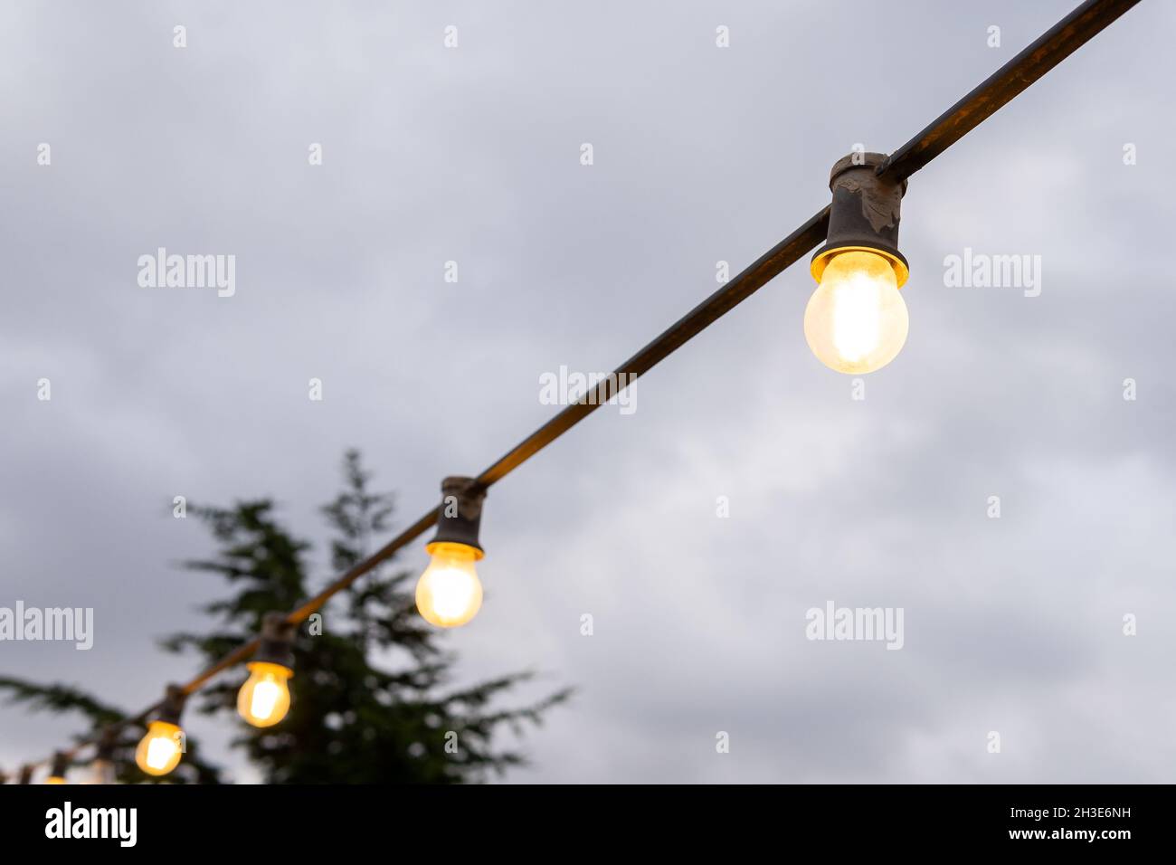 From below hanging light bulbs under a cloudy sky Stock Photo - Alamy