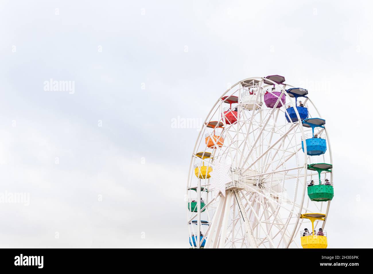 Round public observation wheel with multicolored passenger cabins ...