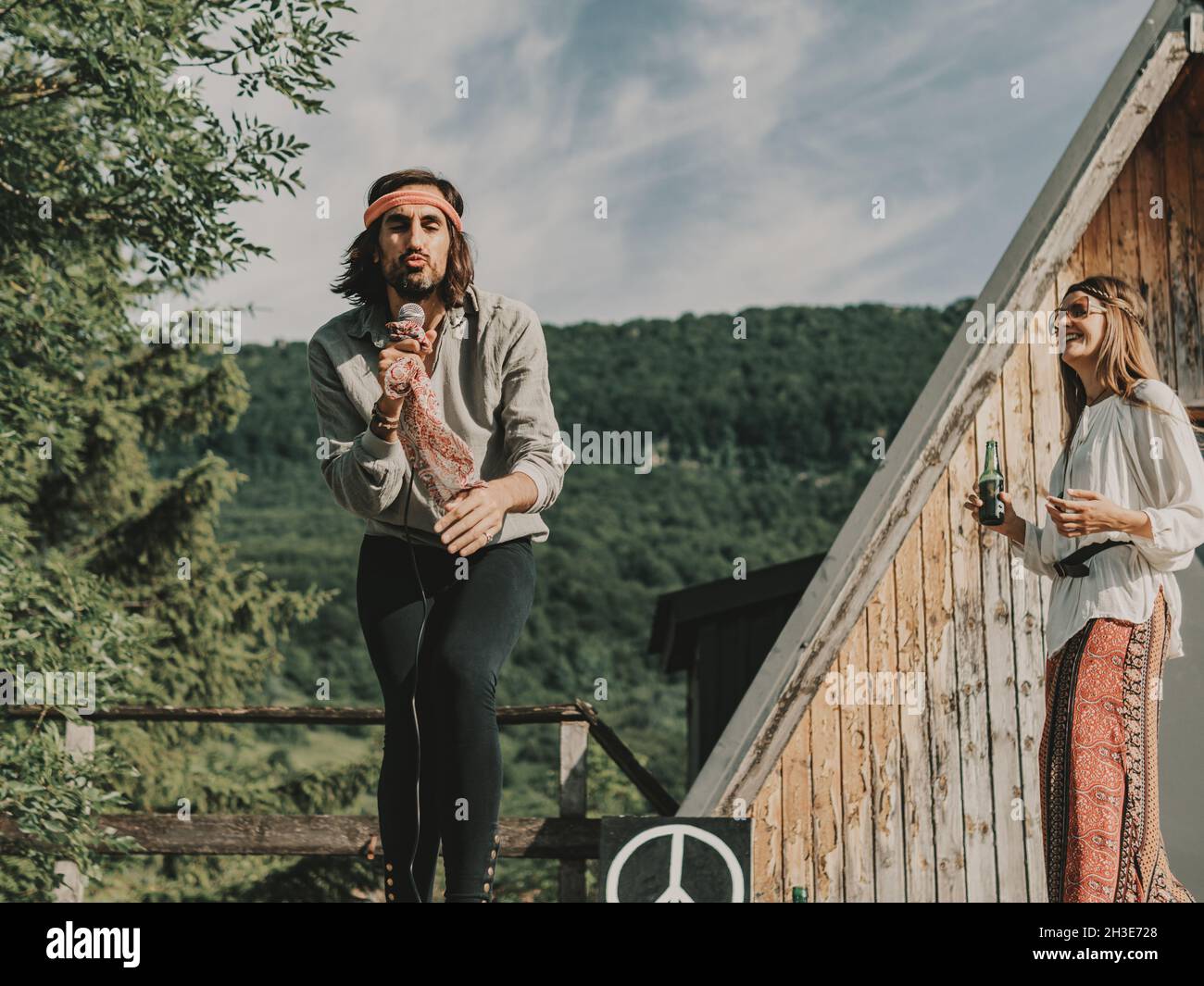 Hippie couple singing and drinking alcohol drinks while resting ...