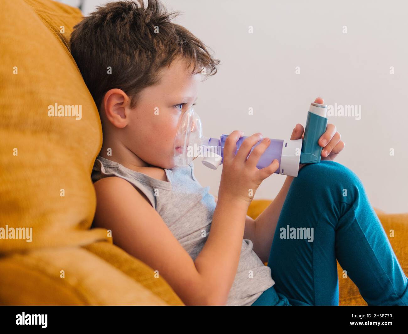 Side view of content sick boy using respirator and breathing oxygen ...