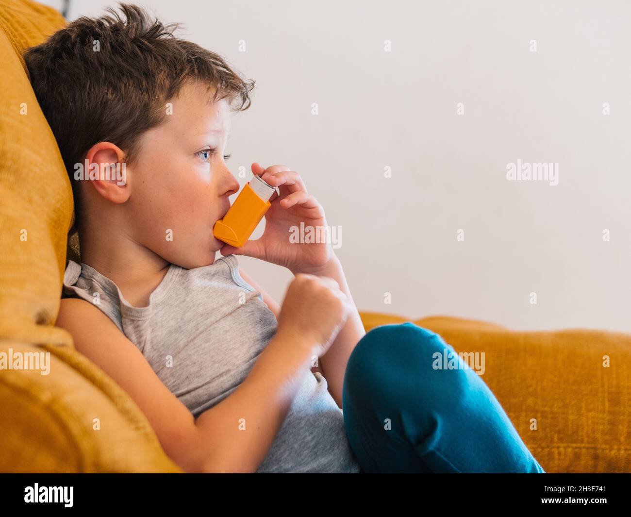Side view of content sick boy using respirator and breathing oxygen ...